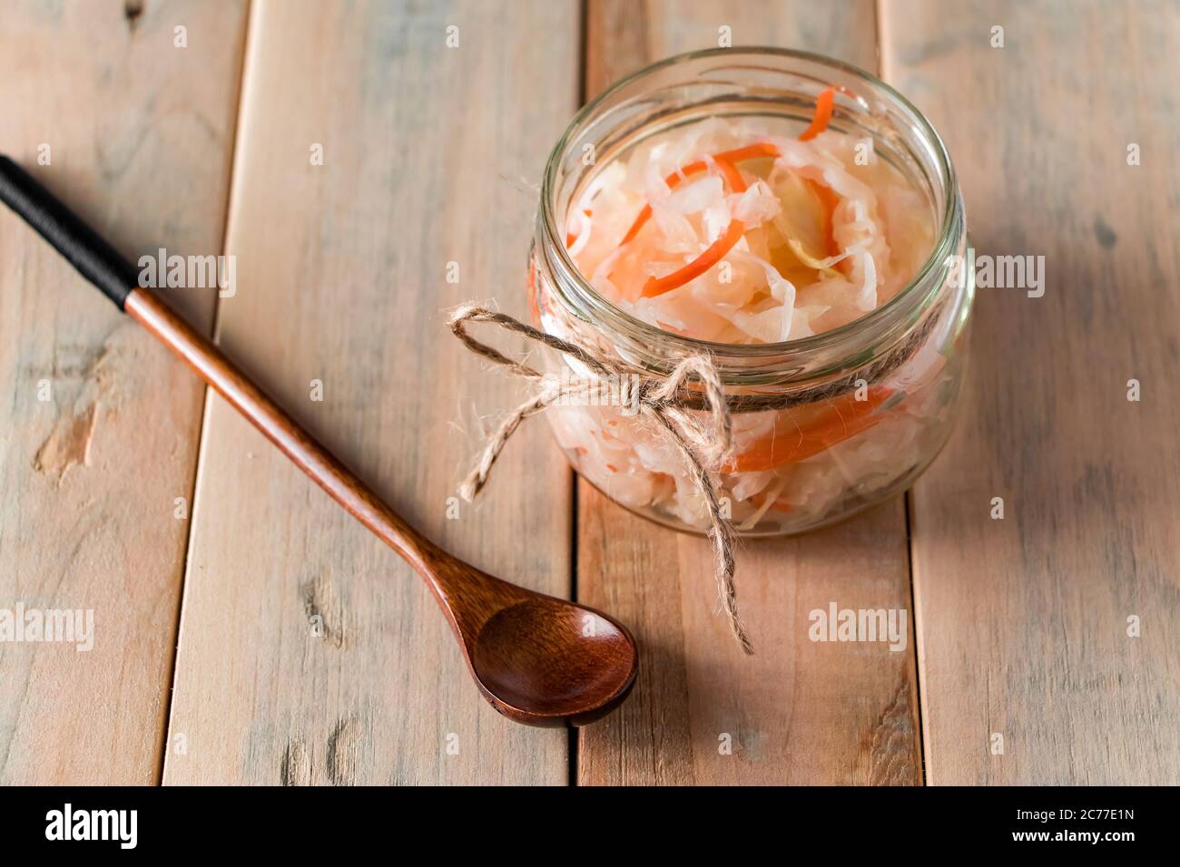 Homemade sauerkraut on a light wooden background. Glass jar with ...