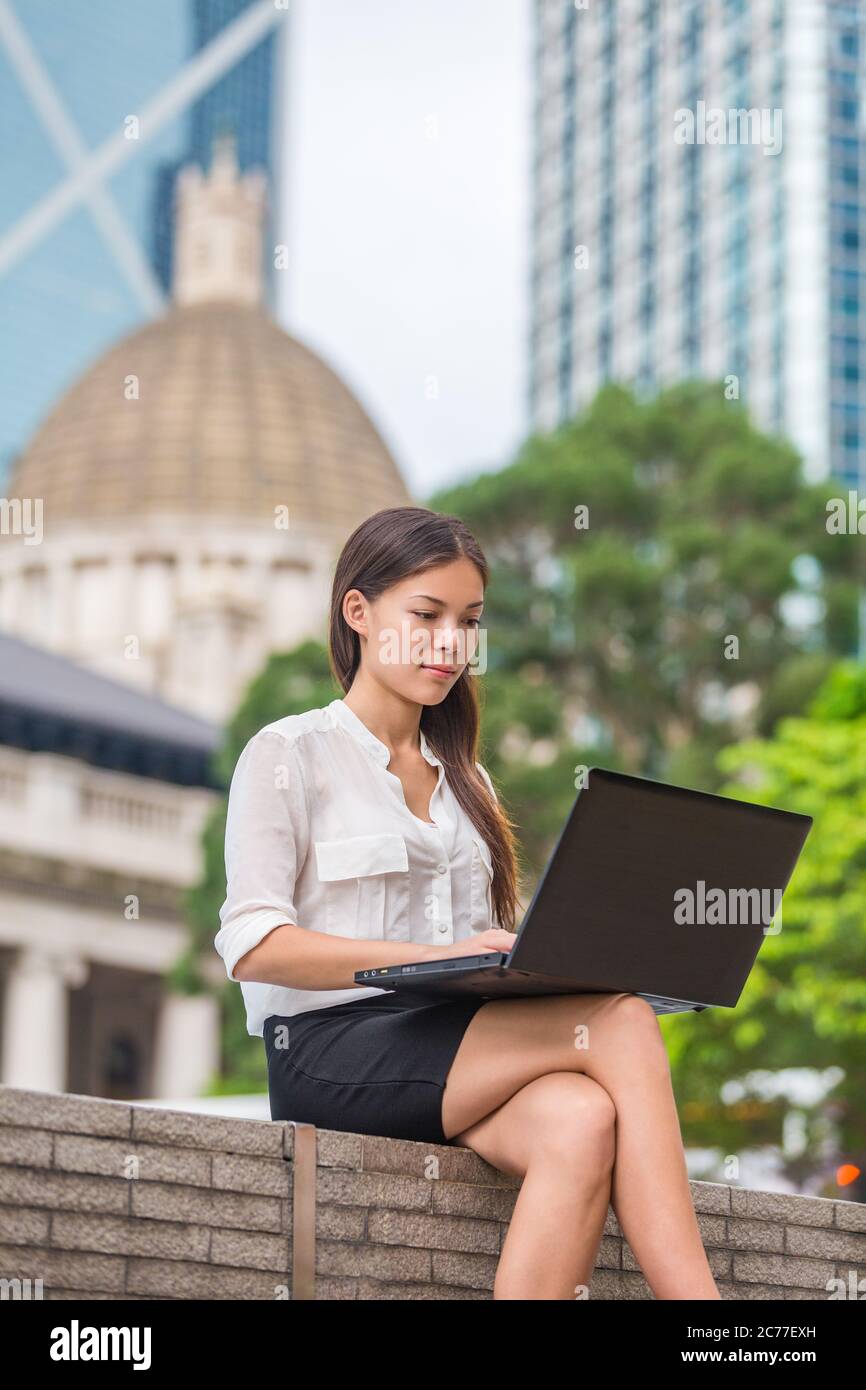 Business woman with computer laptop working outside looking at screen ...