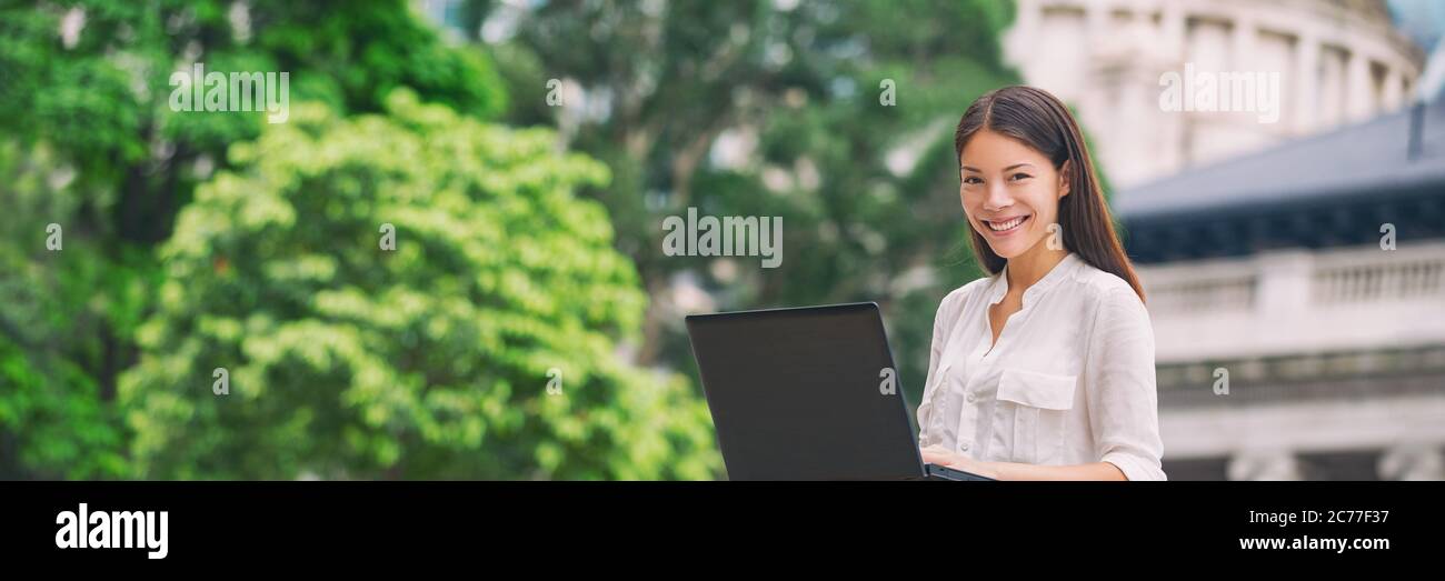 Asian woman working on laptop computer laptop at outside cafe city park ...