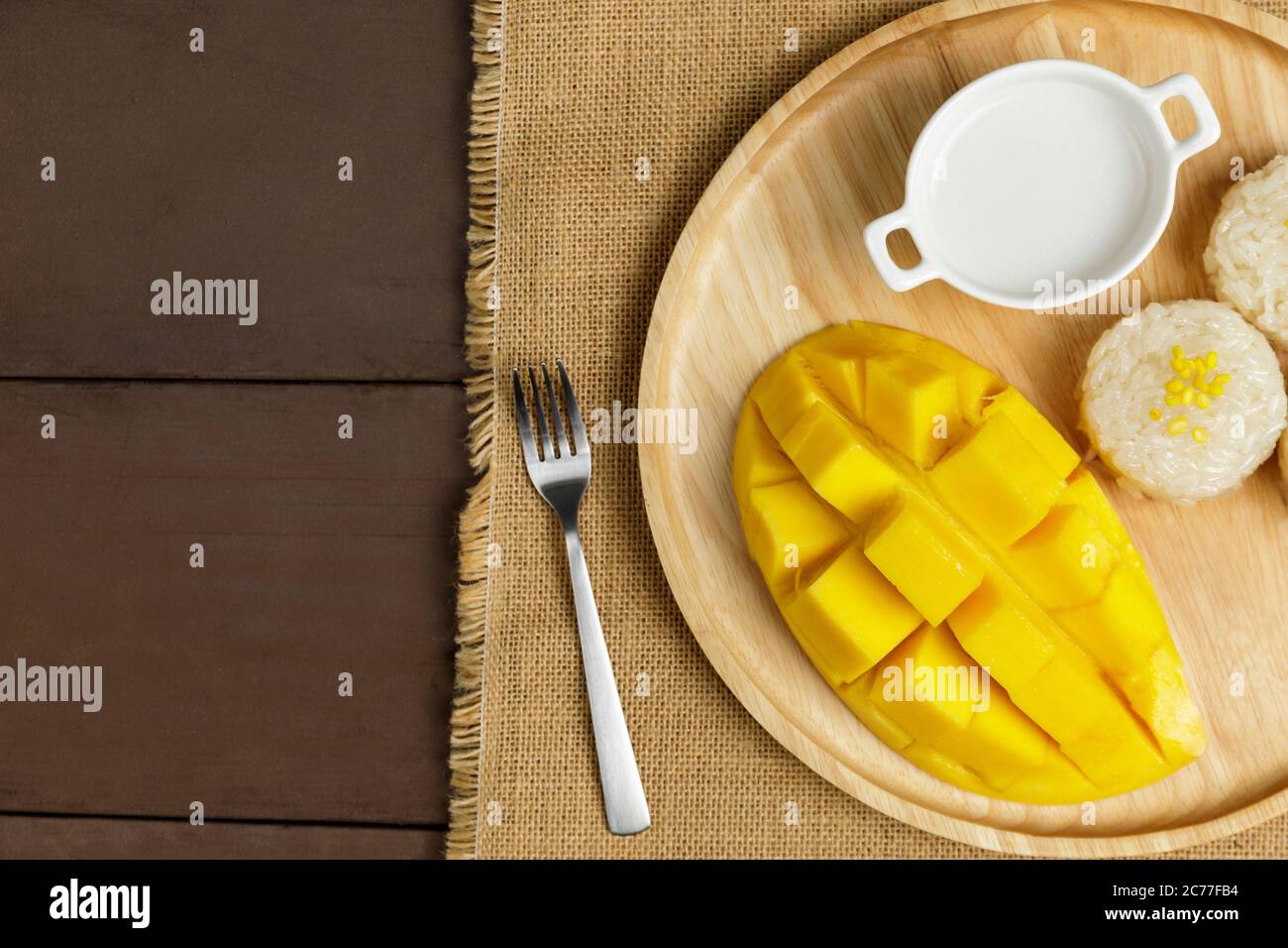 Top view Yellow half mango with small fork. Mango fruit cubes on the ...