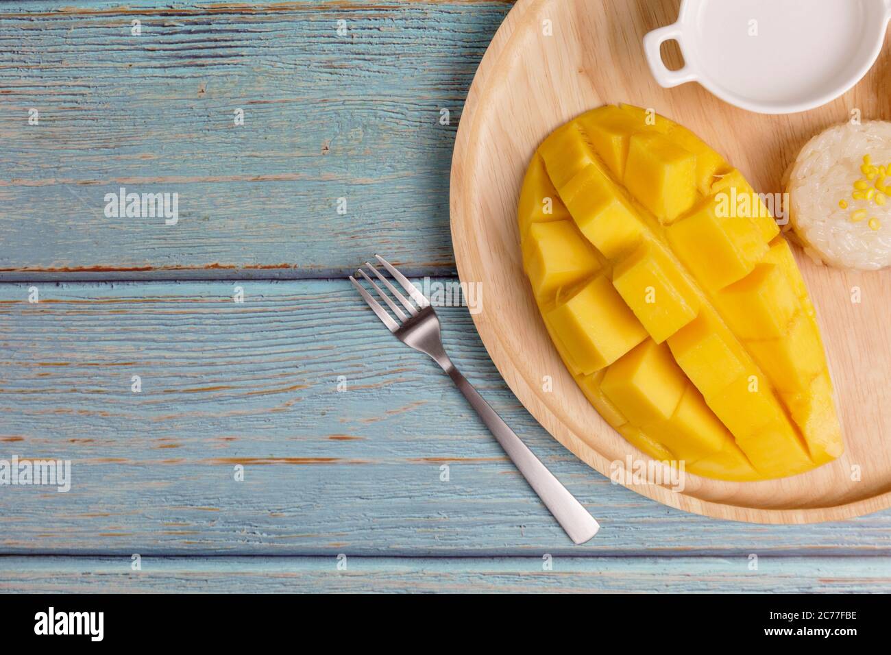 Top view Yellow half mango with small fork. Mango fruit cubes on the ...