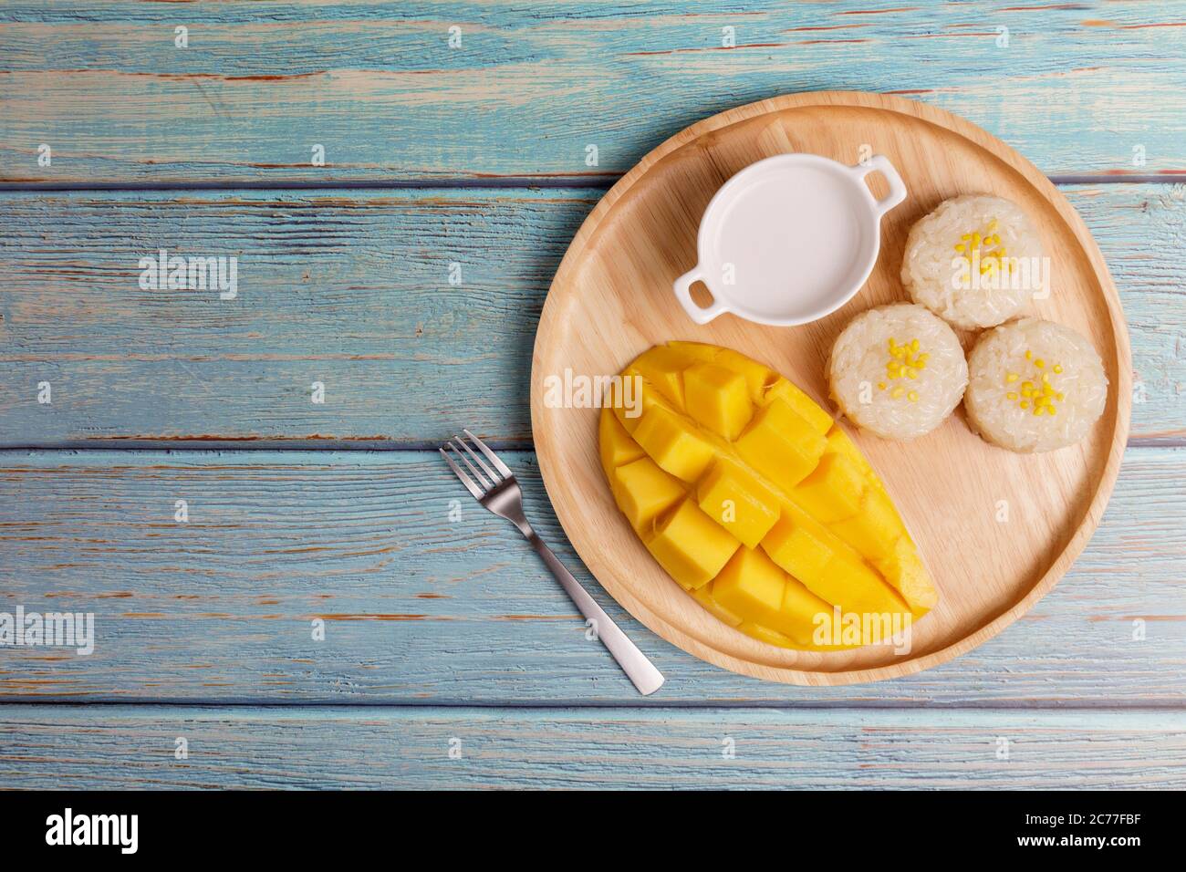 Top view Yellow half mango with small fork. Mango fruit cubes on the ...