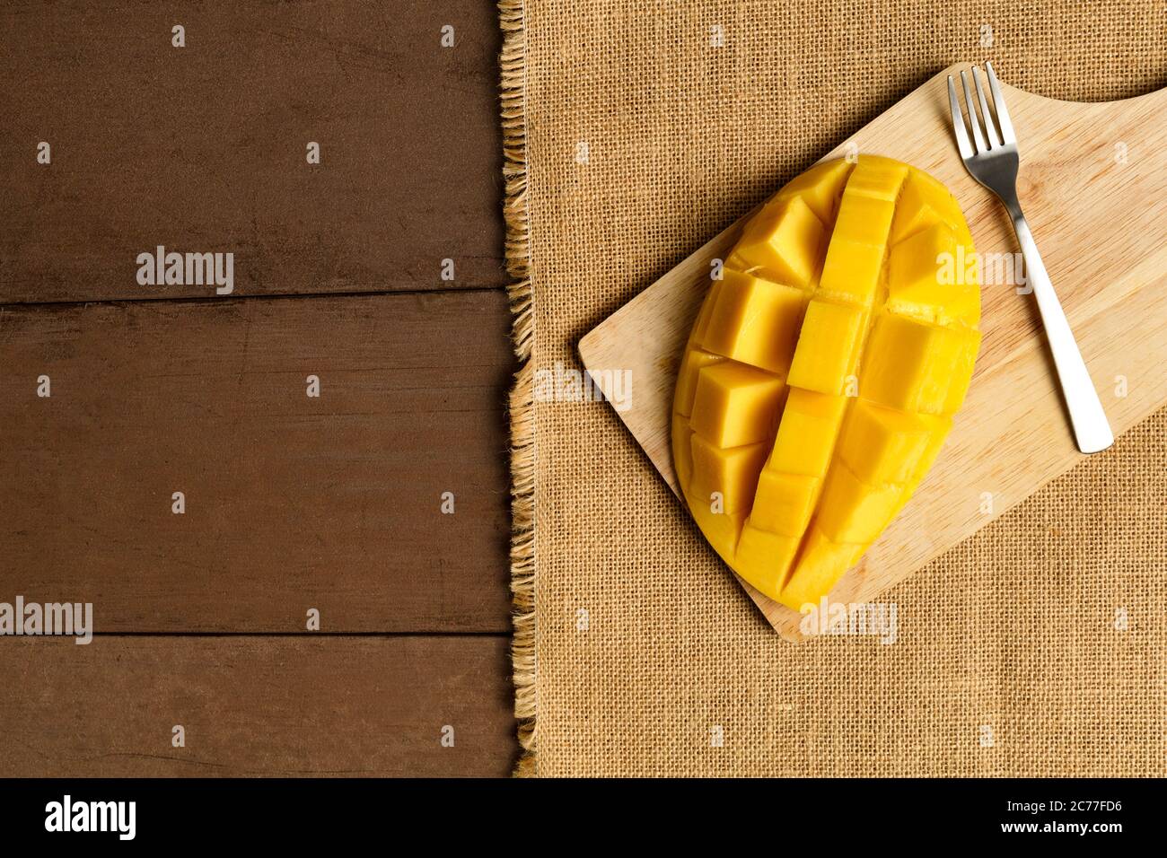 Top view yellow half mango with small fork. Mango fruit cubes on the ...