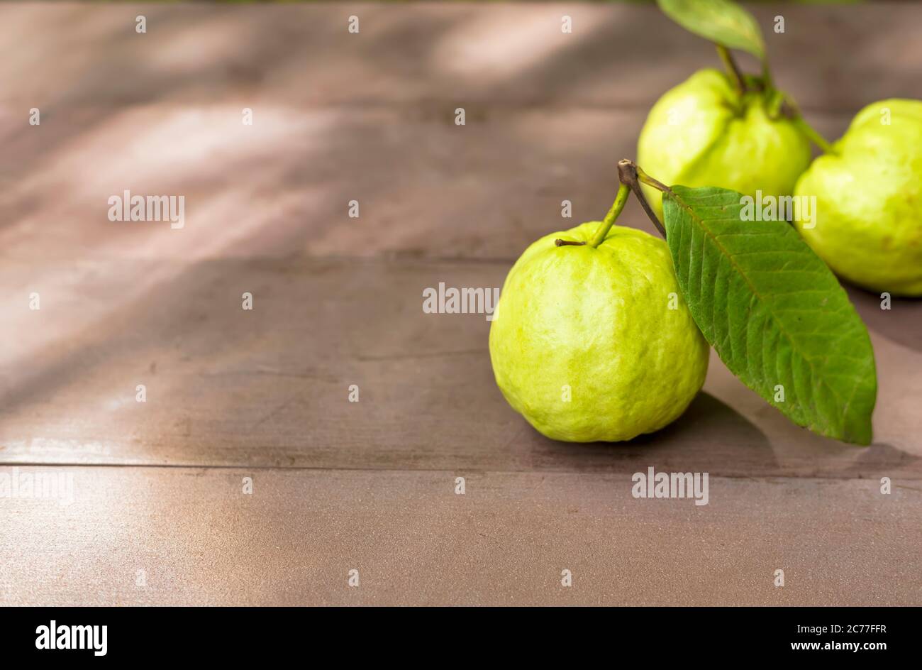 Fresh guava fruit on wood table with sun ray Stock Photo - Alamy