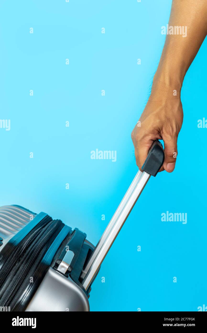 Hand man holding Travel bag on blue background. Hand holding Silver ...