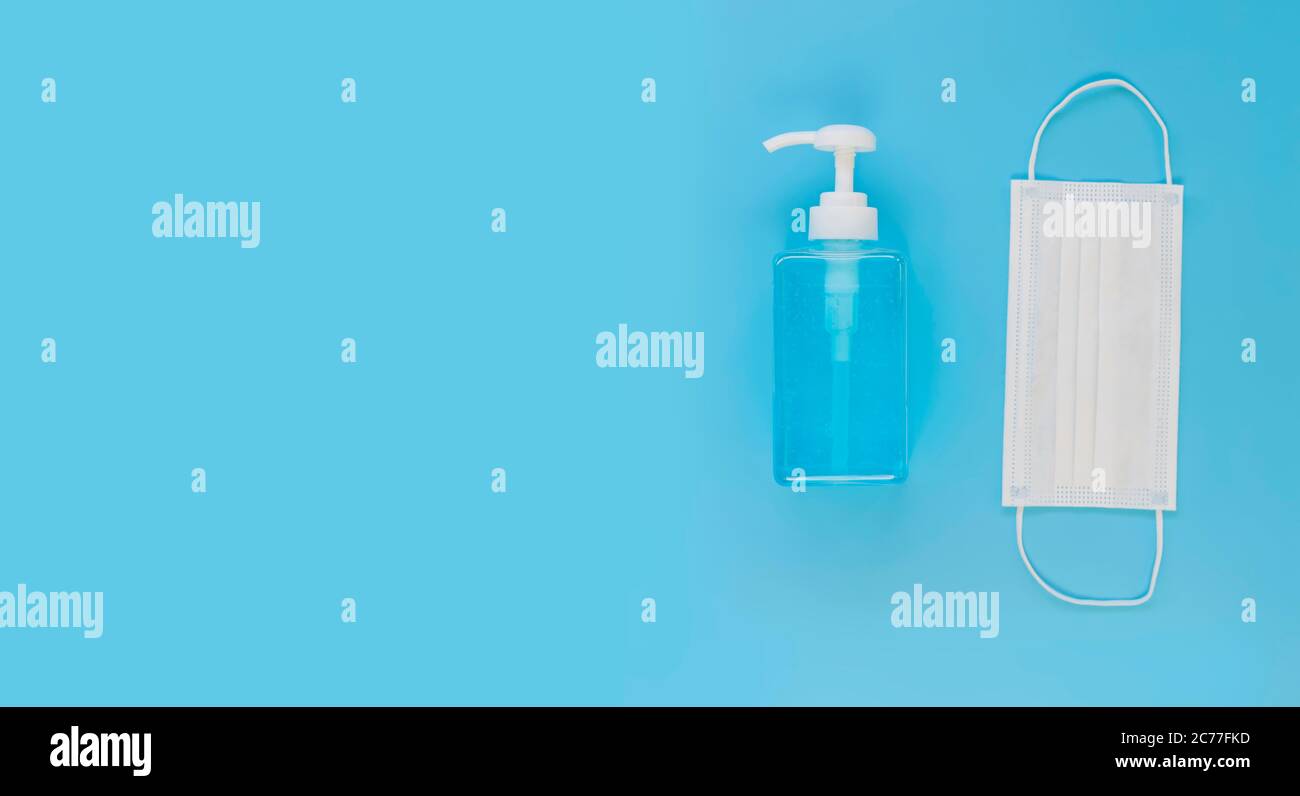 Top view medical face mask and alcohol gel on light blue background ...