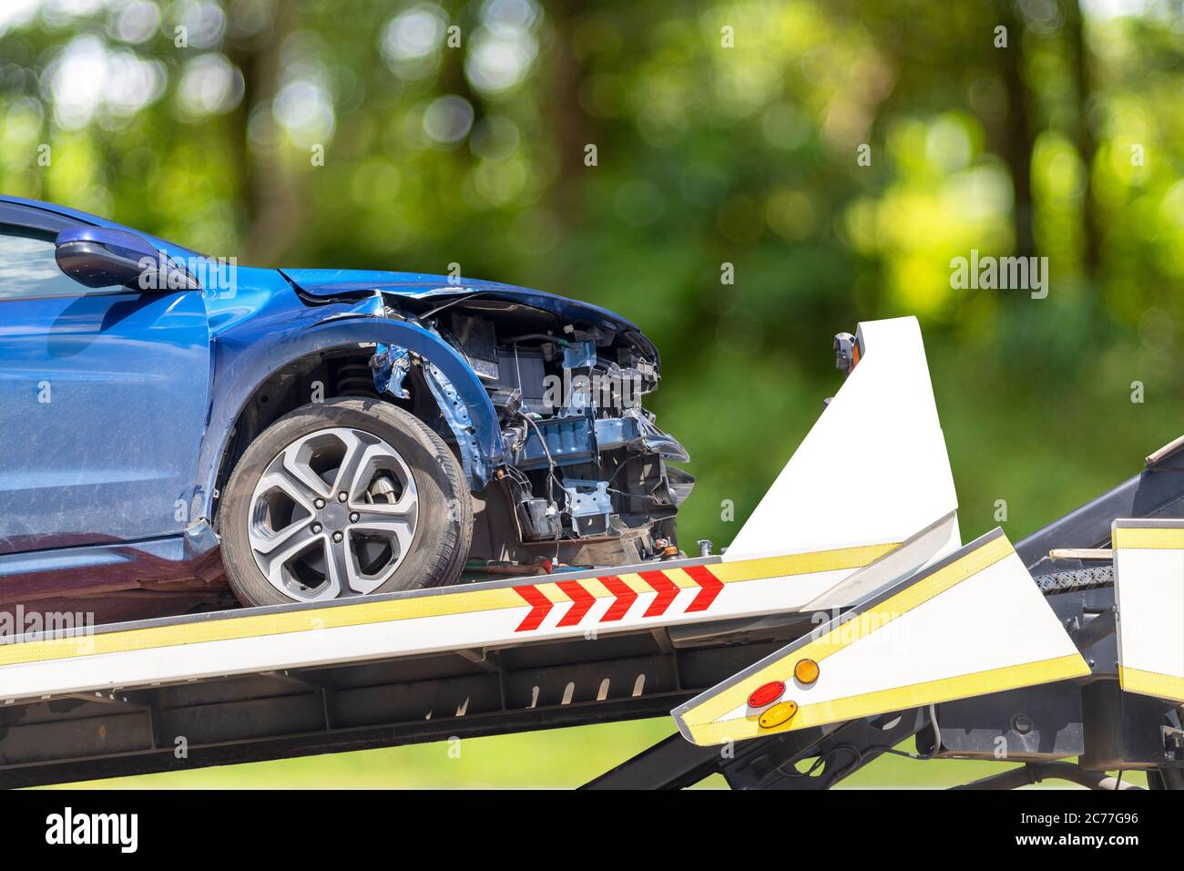 accident Car Slide on truck for move. Blue car have damage by accident ...