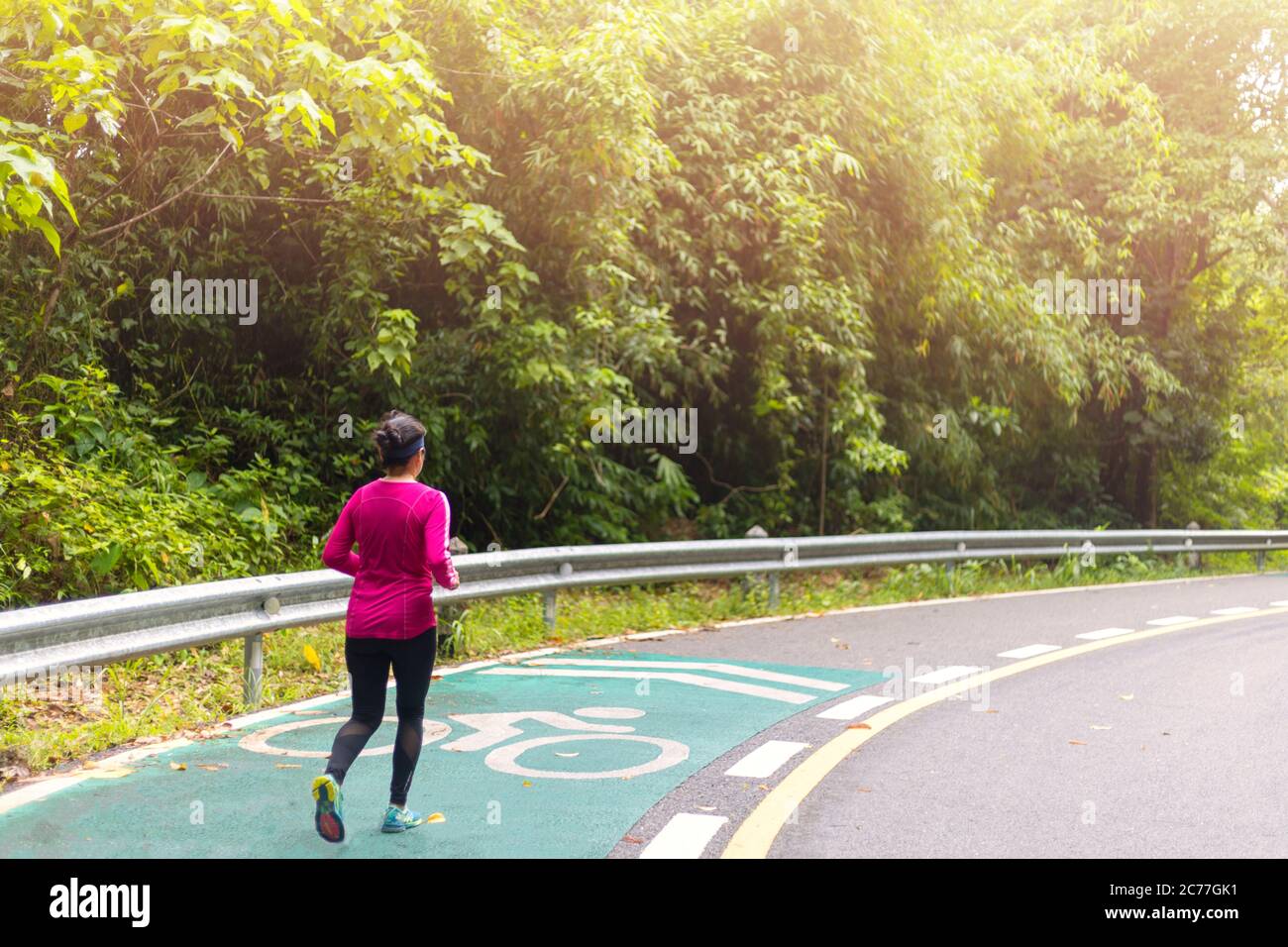 Women with pink long sleeve runing on road in morning time Stock Photo ...