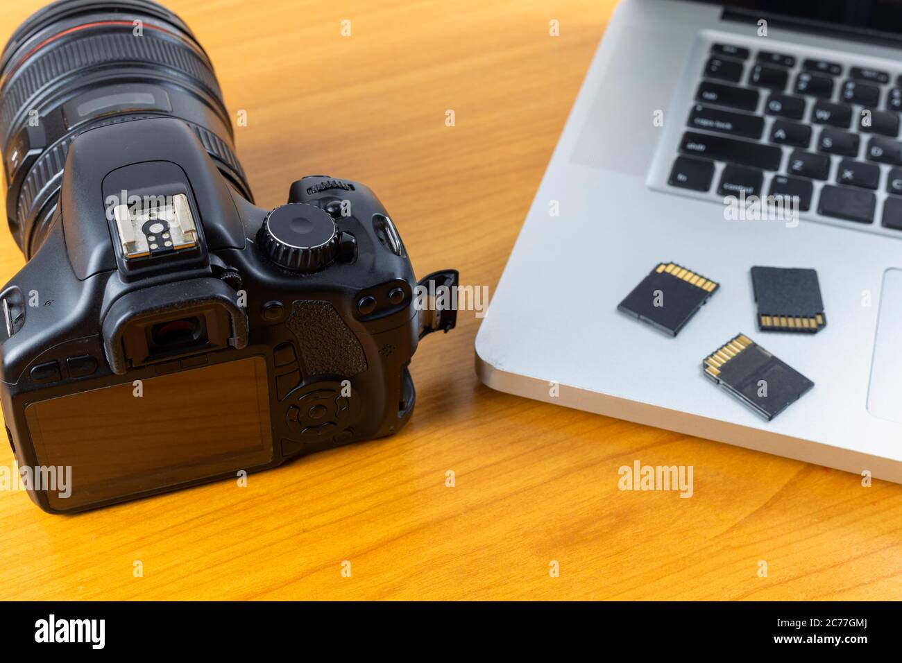 Digital camera, Laptop and memory card on wood table. With copy space ...