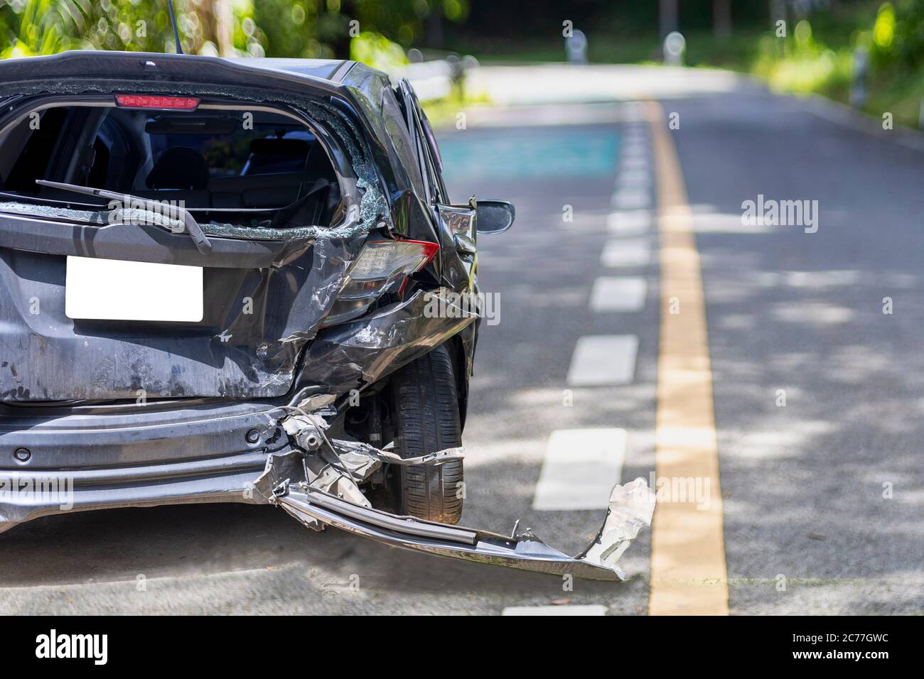Back side of black color car big damaged and broken by accident on road ...