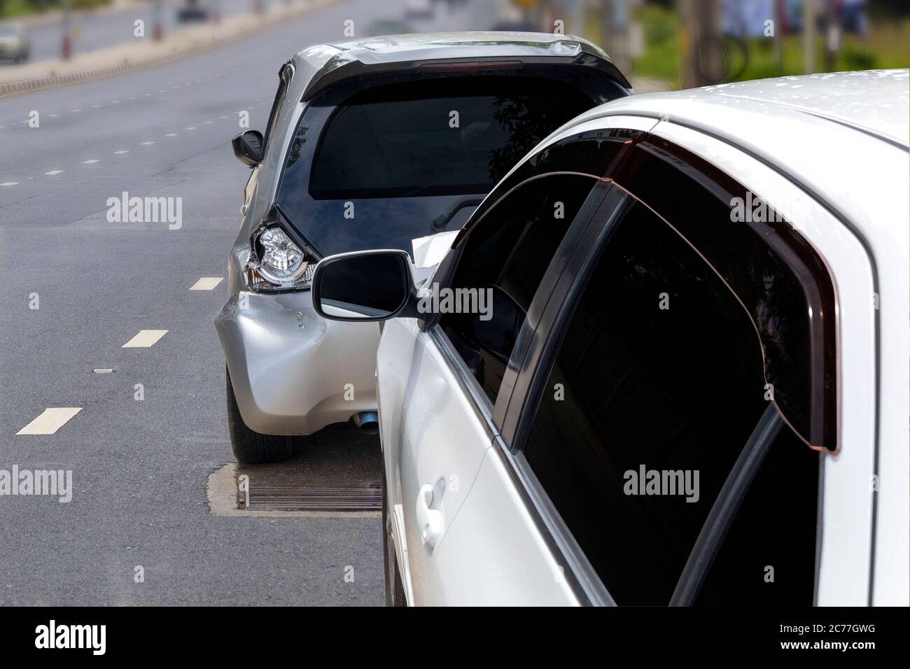 Front of white color car crash with back side of black color car ...