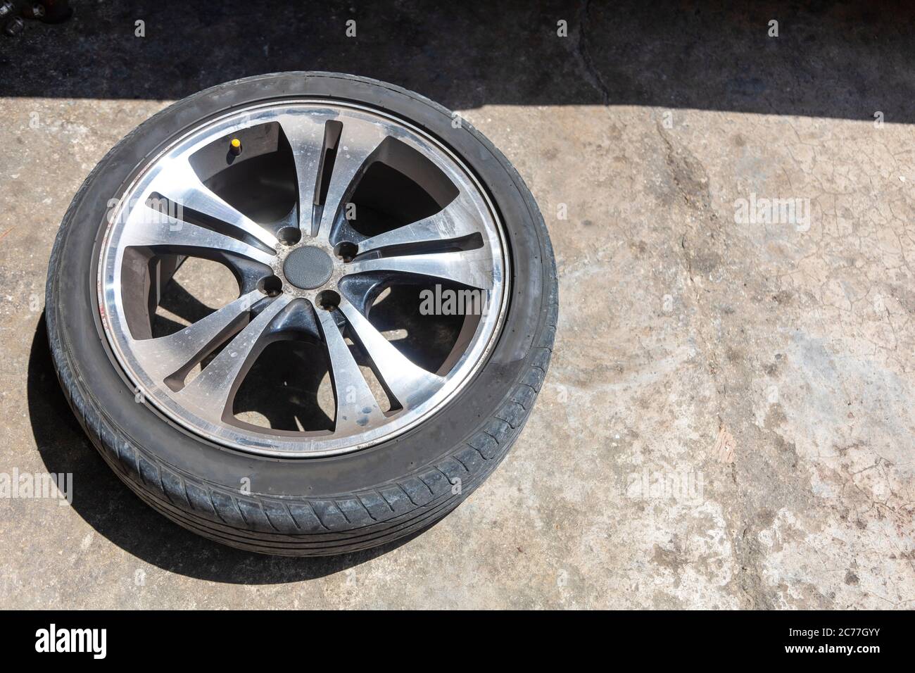One car wheel with tyre on ground. With copy space for text or design ...