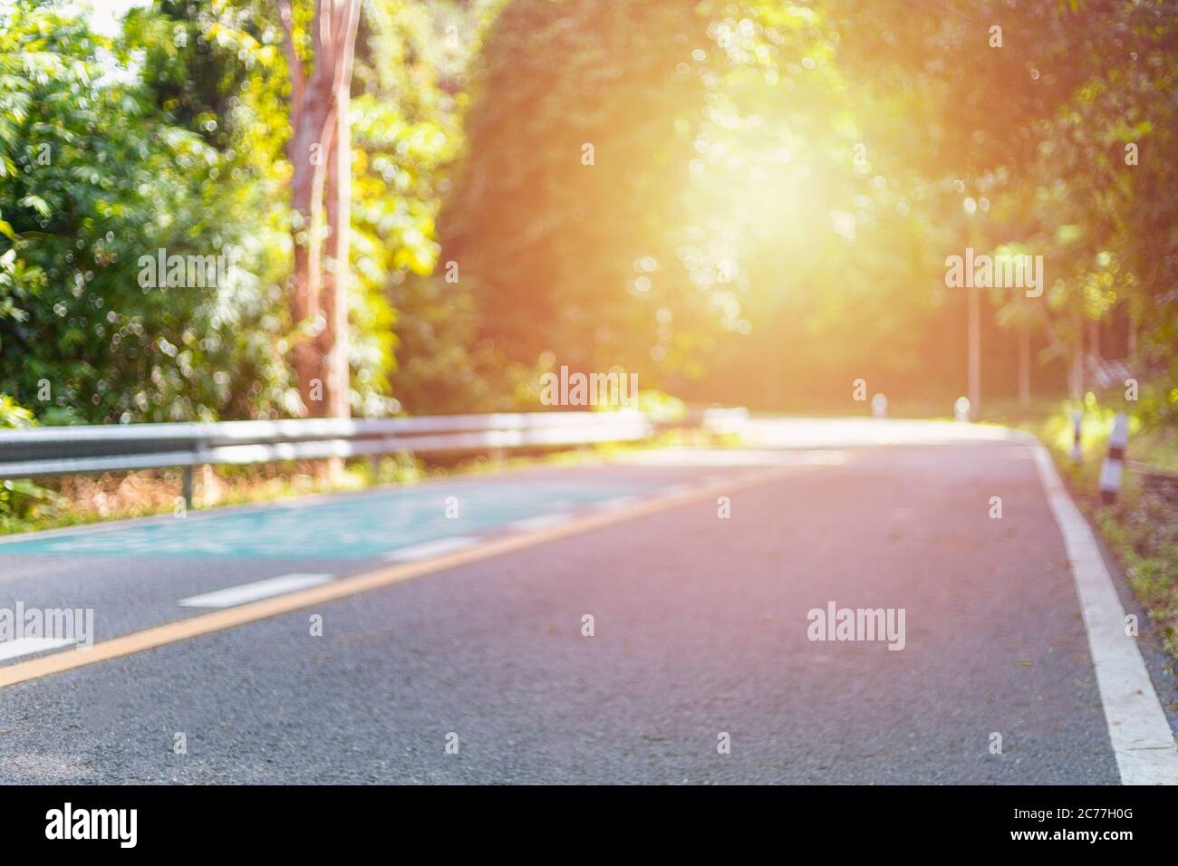 Abstract blurred road and nature background with bright sunlight. With ...