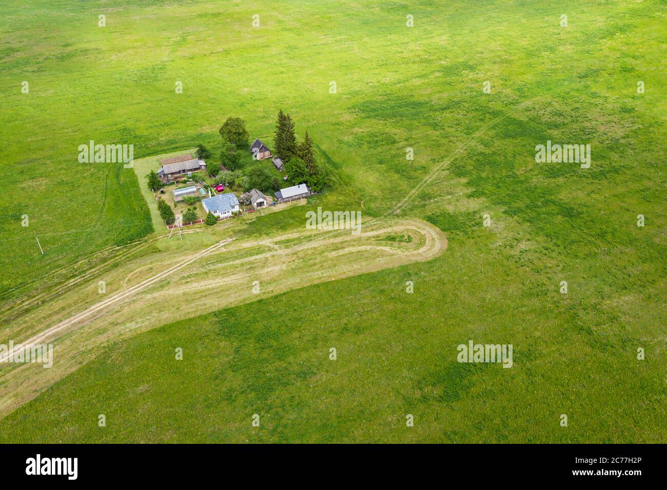 aerial landscape with farm house, equipment and warehouses among green ...