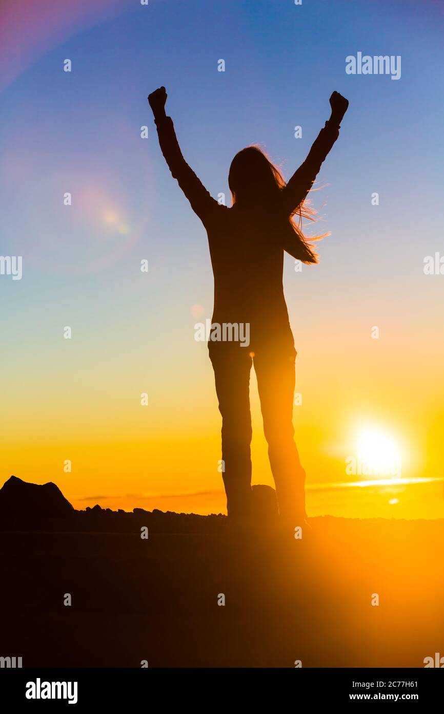 Winner woman winning with open arms in success of reaching mountain top ...