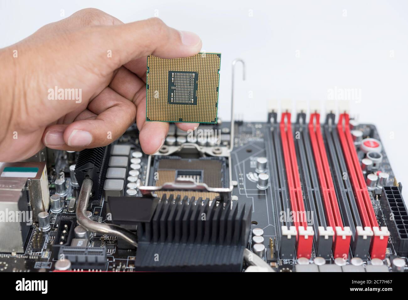 Hand holding CPU show the ic surface and have motherboard open socket ...