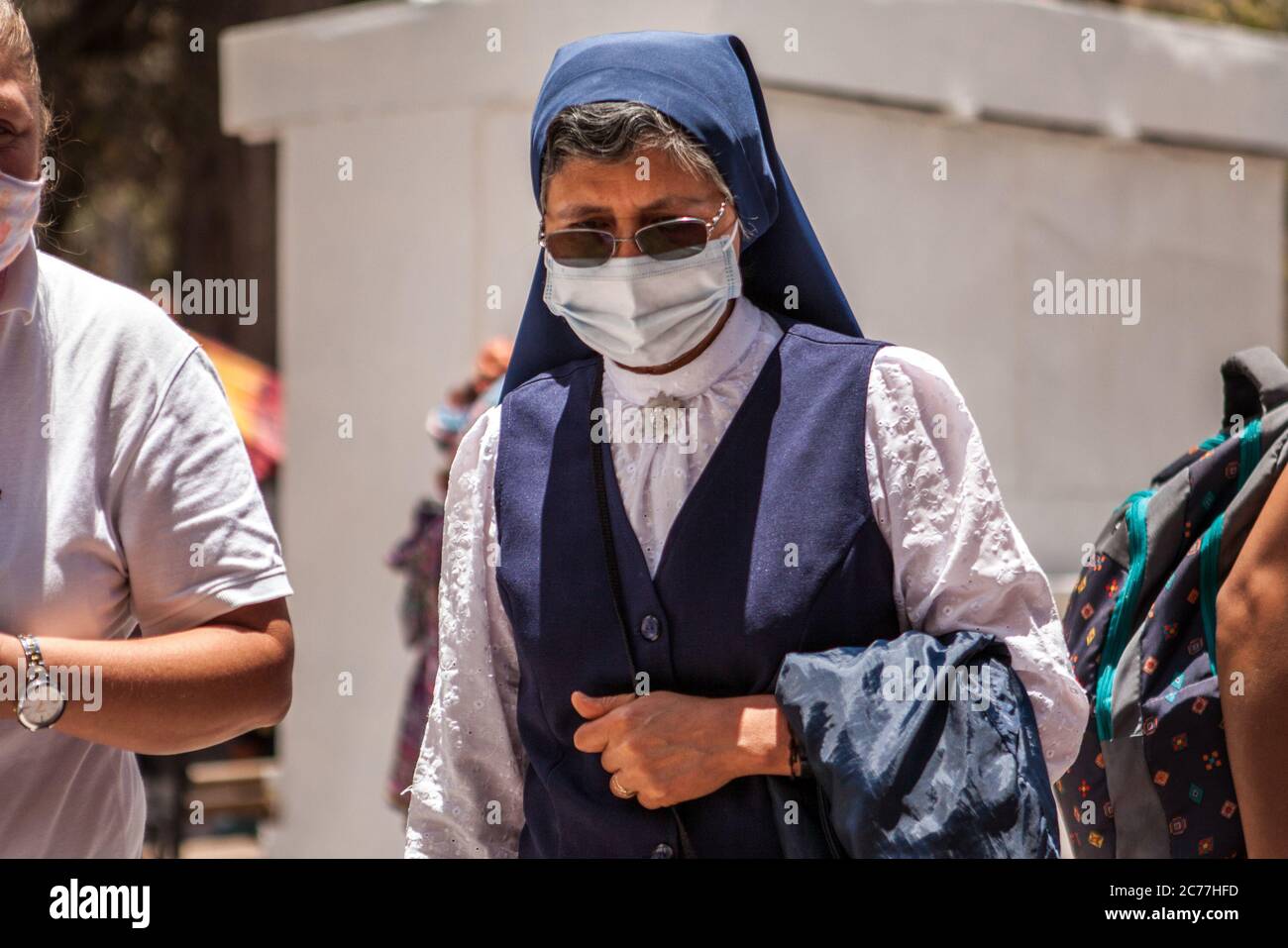 A nun wearing a face mask as a preventive measure walks on the street ...