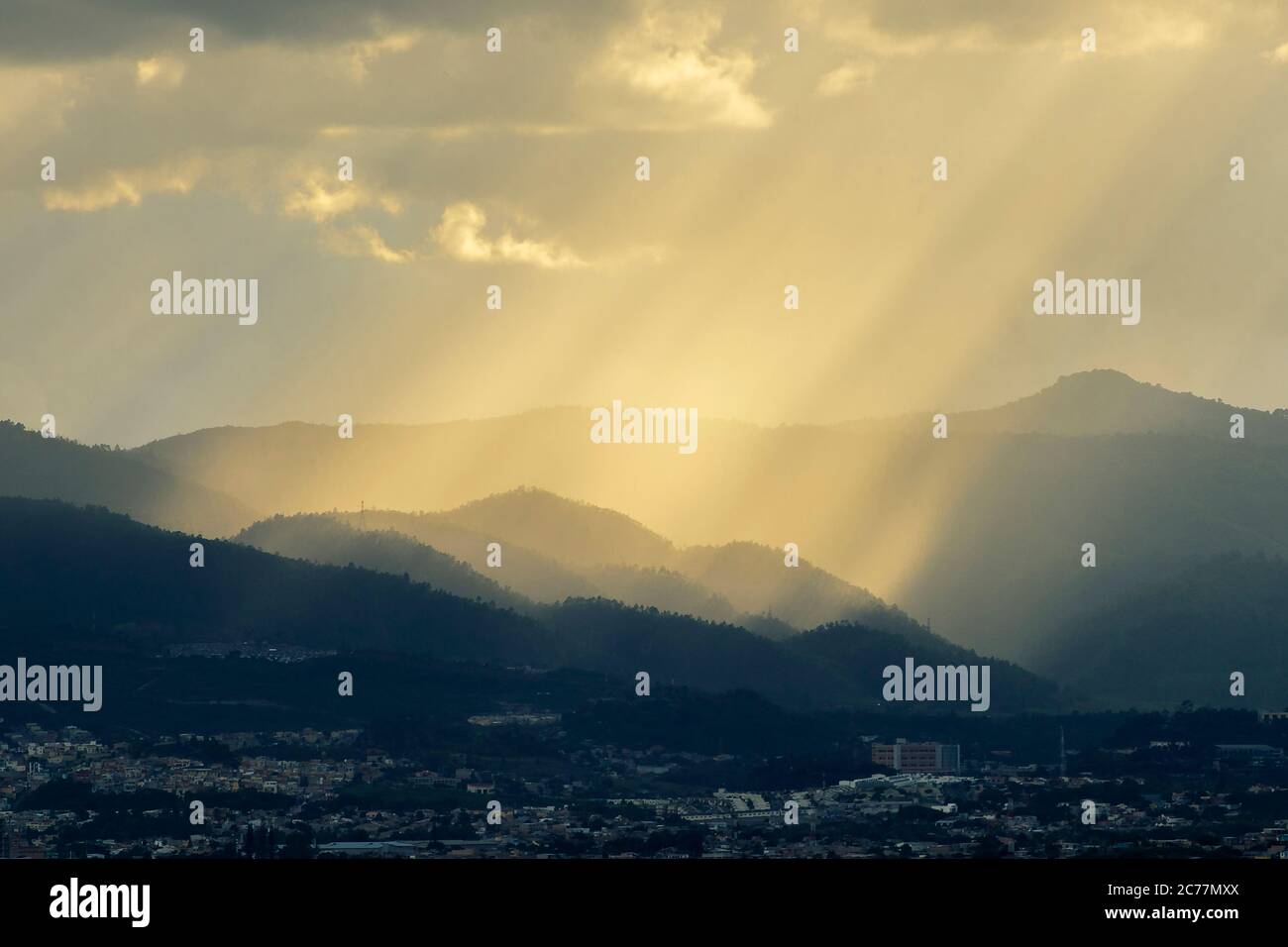 Diagonal sunrays falling down over a hill Stock Photo - Alamy