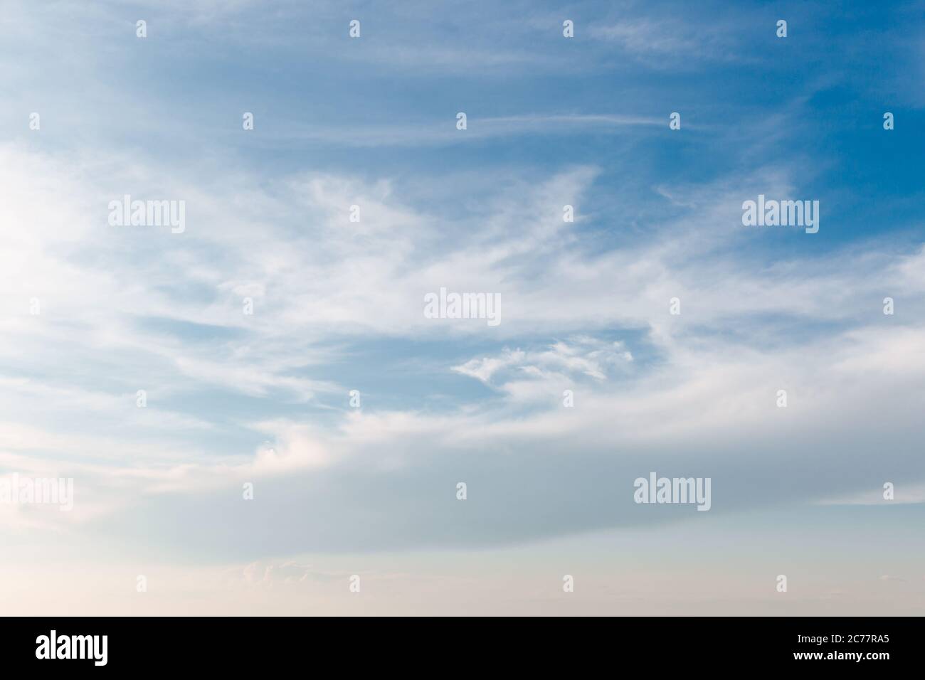 White clouds stretched across the blue sky on a warm sunny day Stock ...