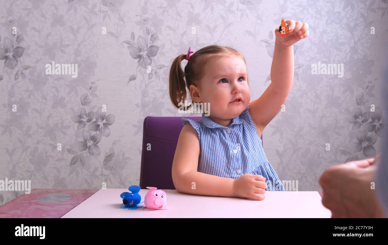 happy smiling little girl makes a crow with her hands with her mother ...