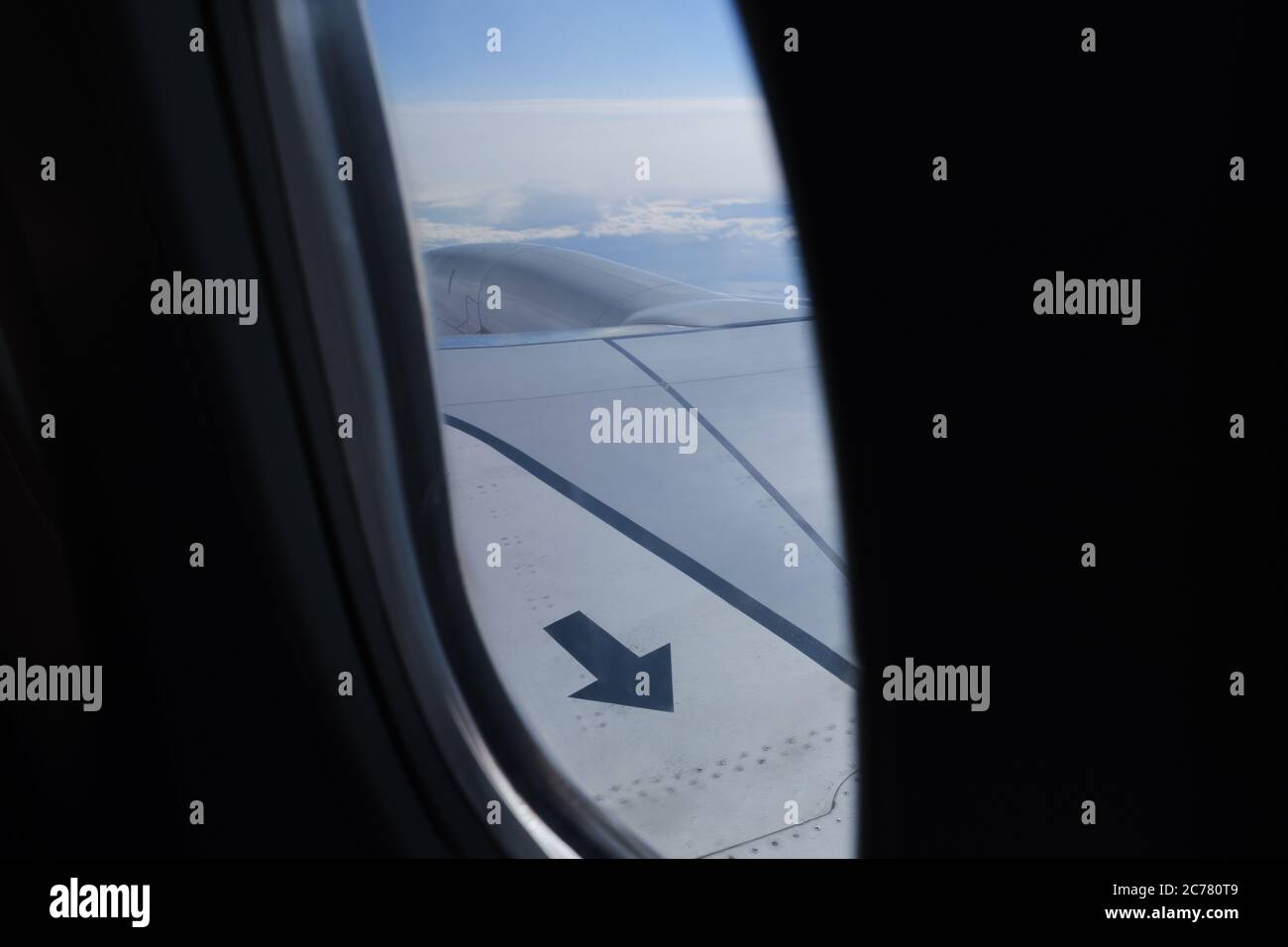 Arrow sign on the airplane wing up in the sky porthole view Stock Photo ...