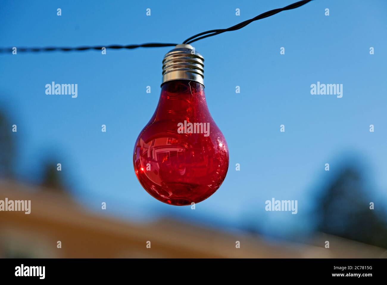 a red light bulb hanging outdoors that only lights up at night Stock ...