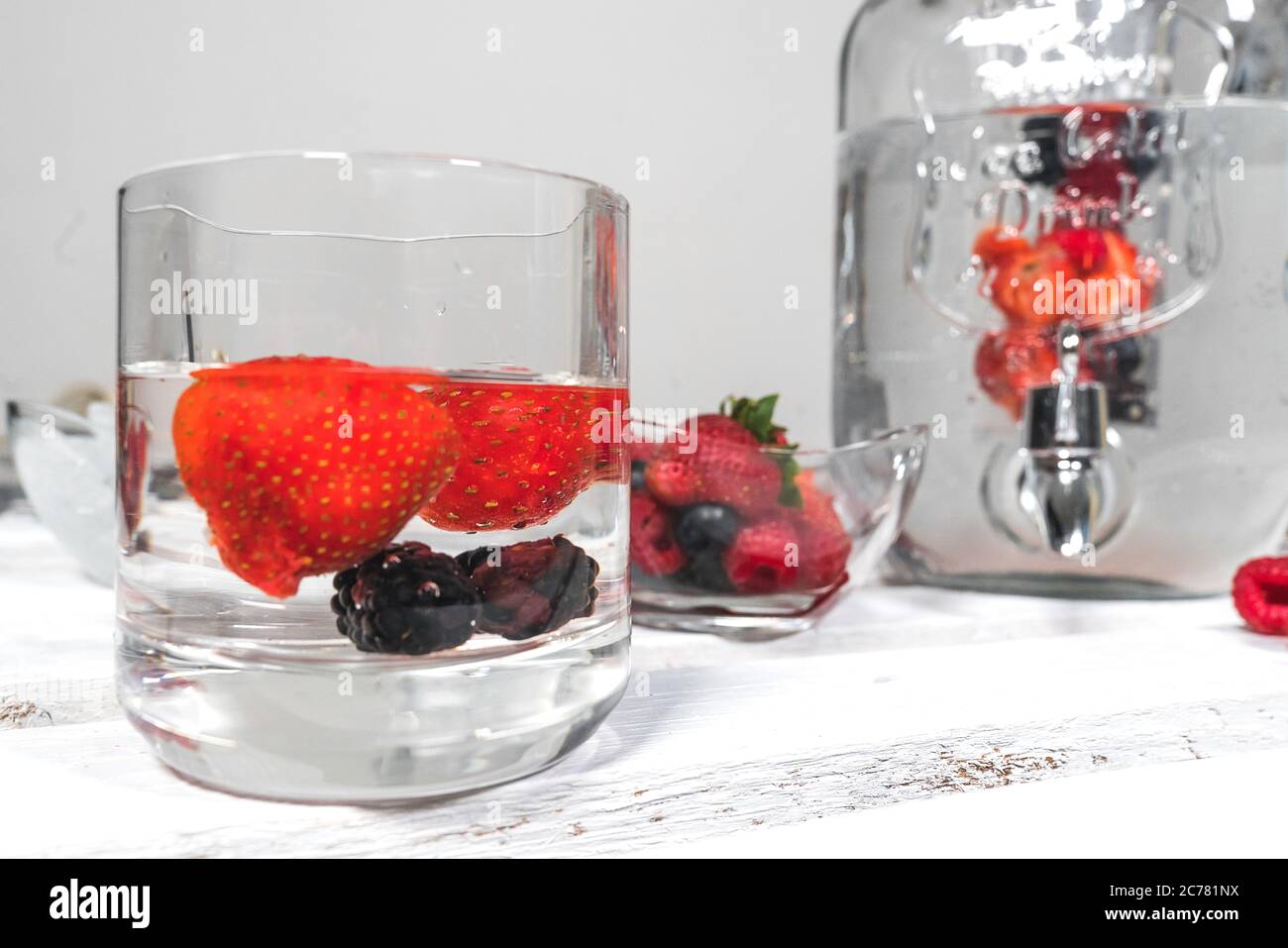 Glass of water flavored with berries. Red fruit flavoured water ...