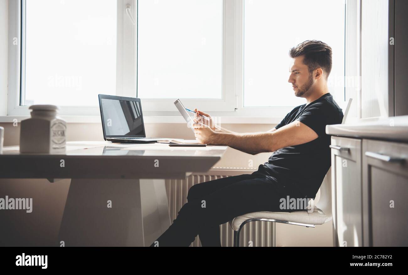 Side view photo of a caucasian man with beard analyzing data while ...