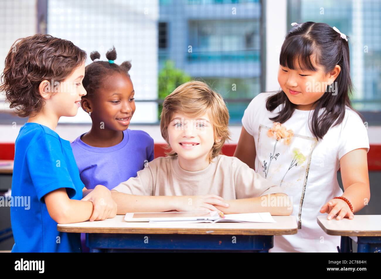 Elementary school scene. Multi ethnic classmates in the classroom ...