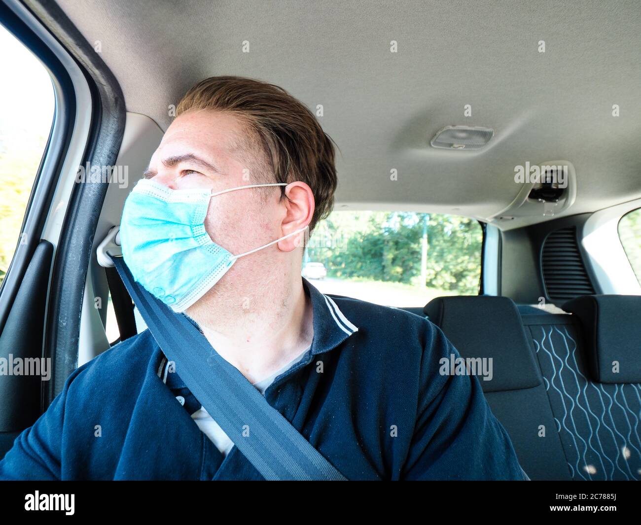 adult caucasian 40s male passenger of a car moving wearing surgical 3 ...
