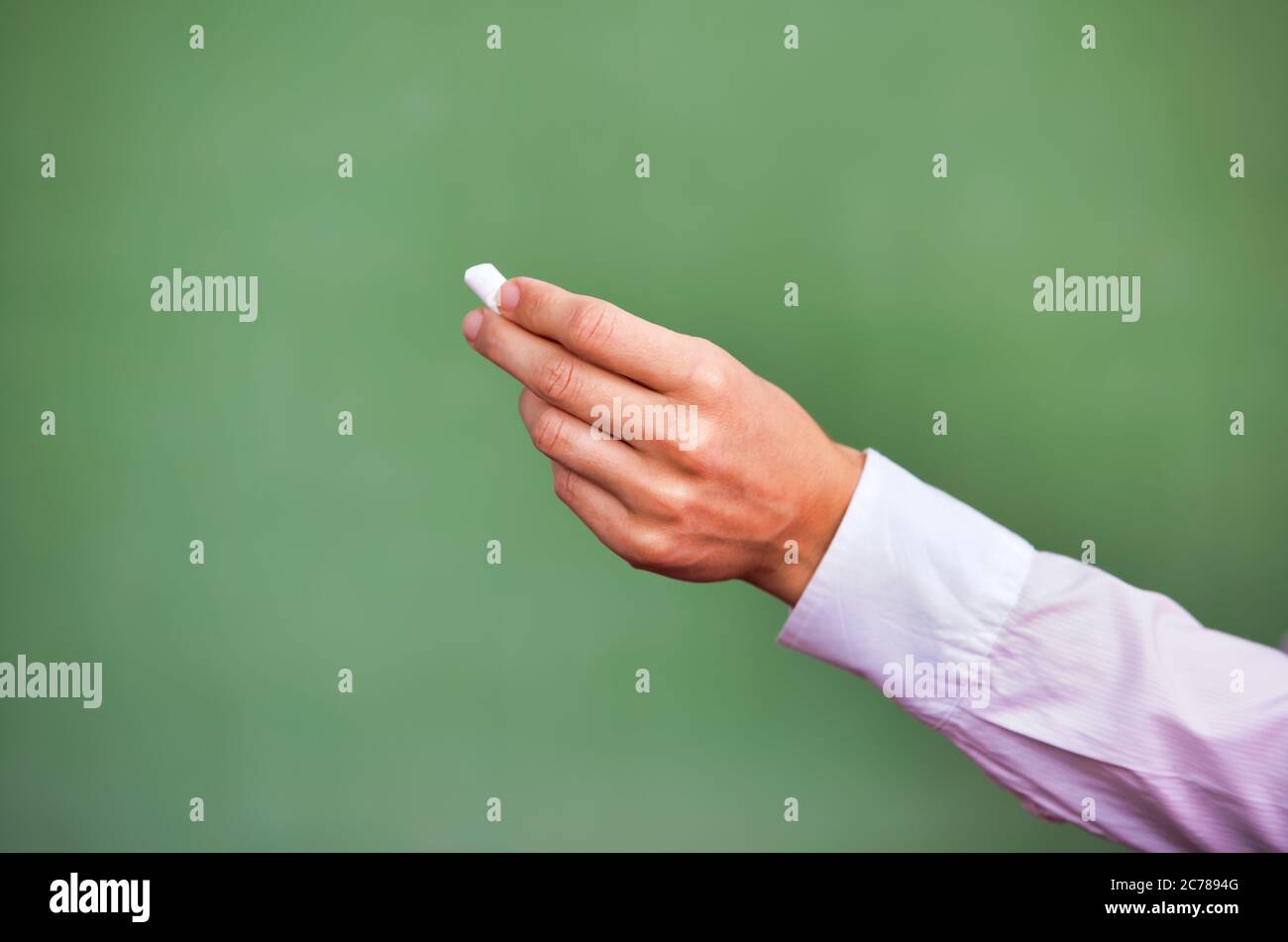 Elementary school scene. Woman hand holding chalk Stock Photo - Alamy