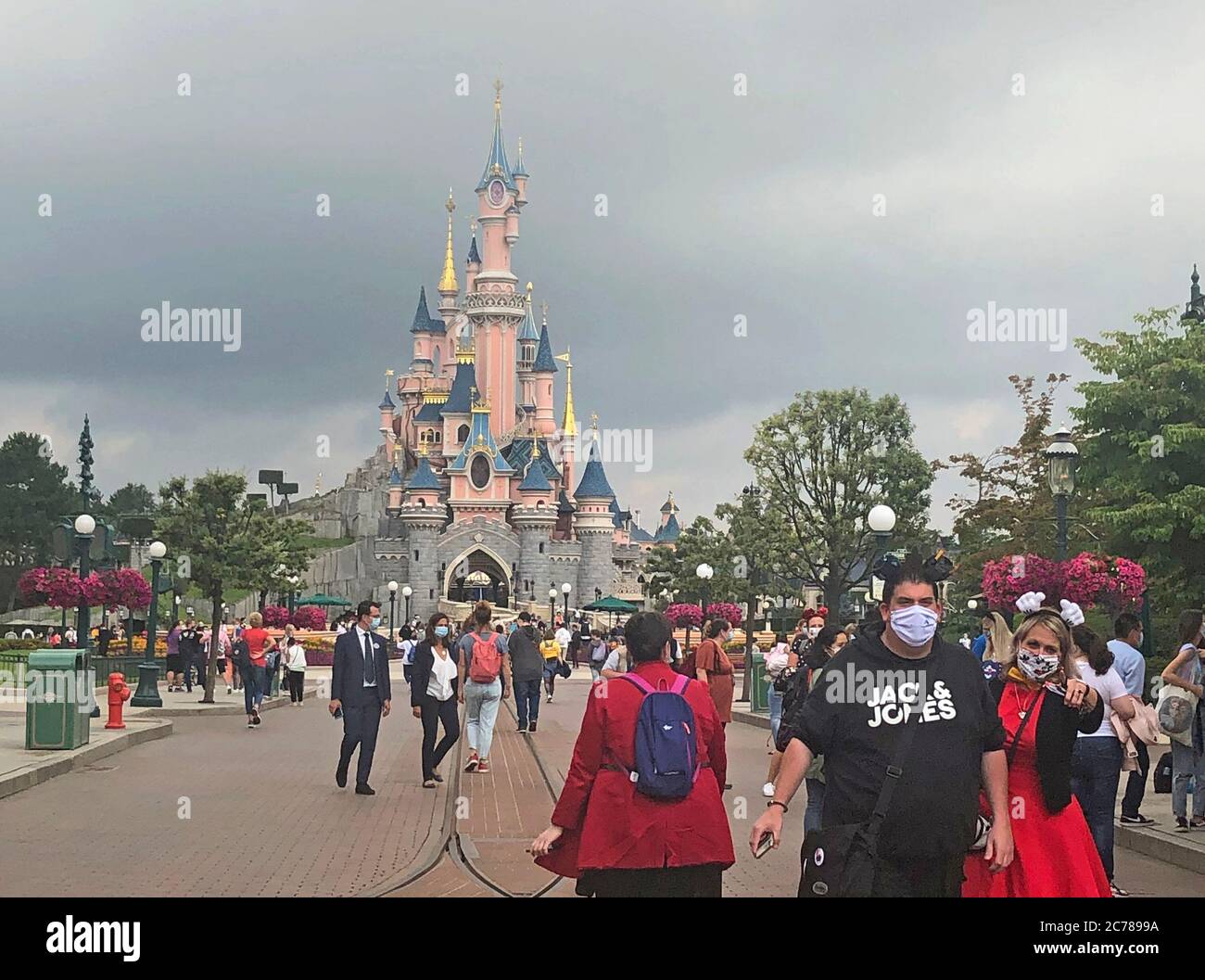 Guests Walk Around The Park Below The Sleeping Beauty Castle As