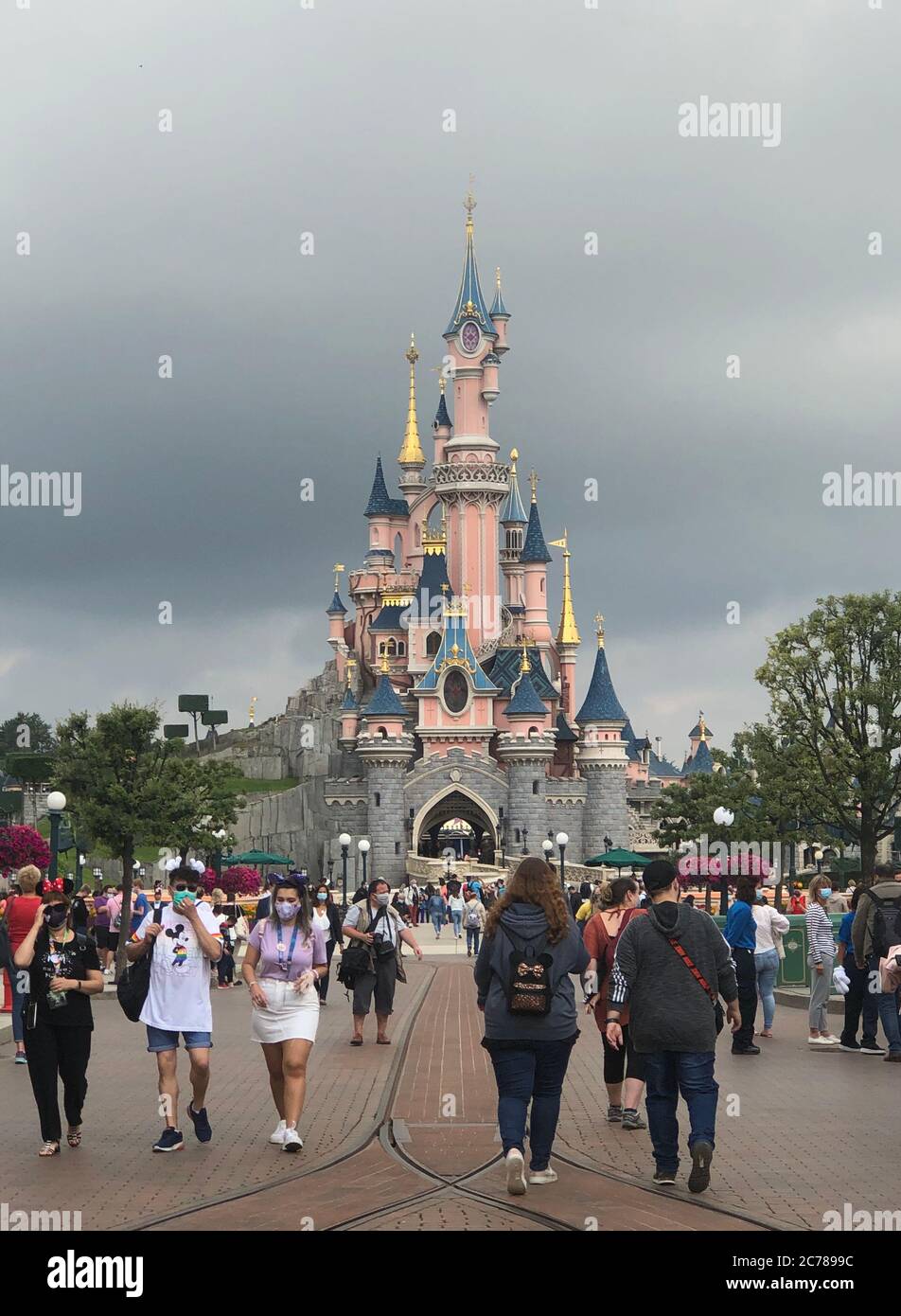Guests Walk Around The Park Below The Sleeping Beauty Castle As