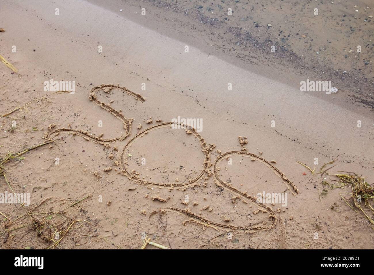 SOS letters in the sand on the beach Stock Photo - Alamy