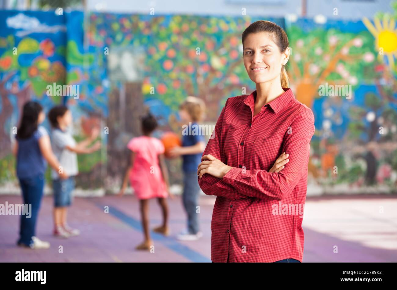 Elementary school scene. Teacher supervising playing children Stock ...