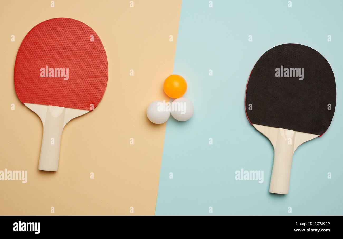 two wooden rackets and plastic balls for playing table tennis, flat lay ...