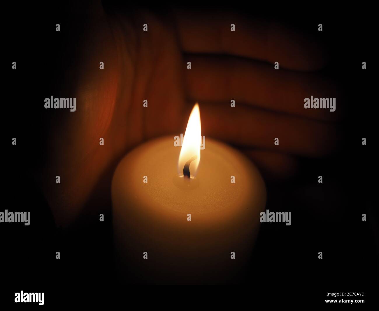 candle in hand on a black background Stock Photo - Alamy
