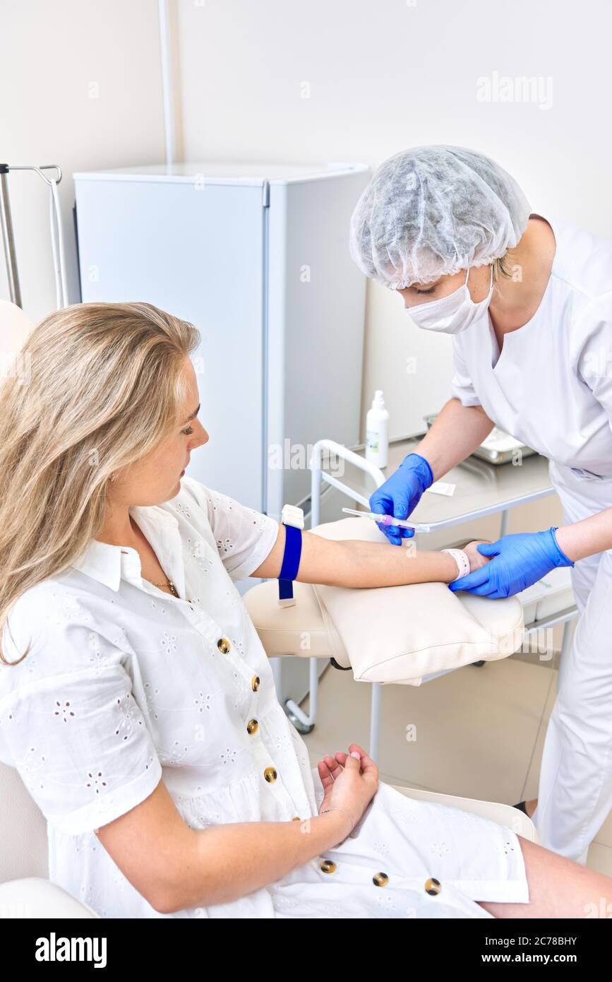 woman gives blood. doctor holds a syringe in his hands Stock Photo - Alamy