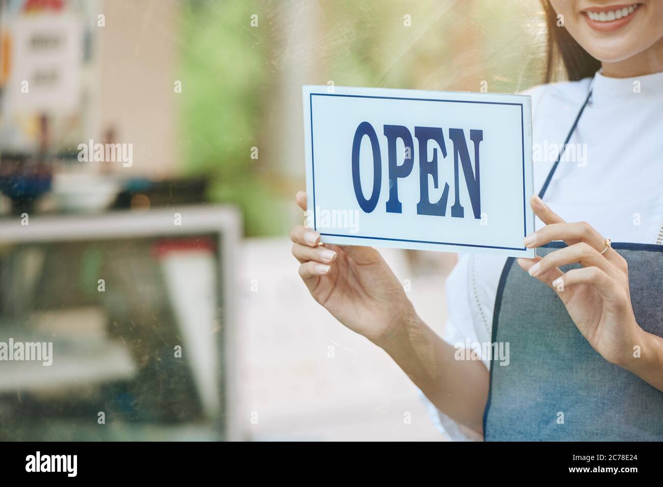 Women hanging open sign hi-res stock photography and images - Alamy