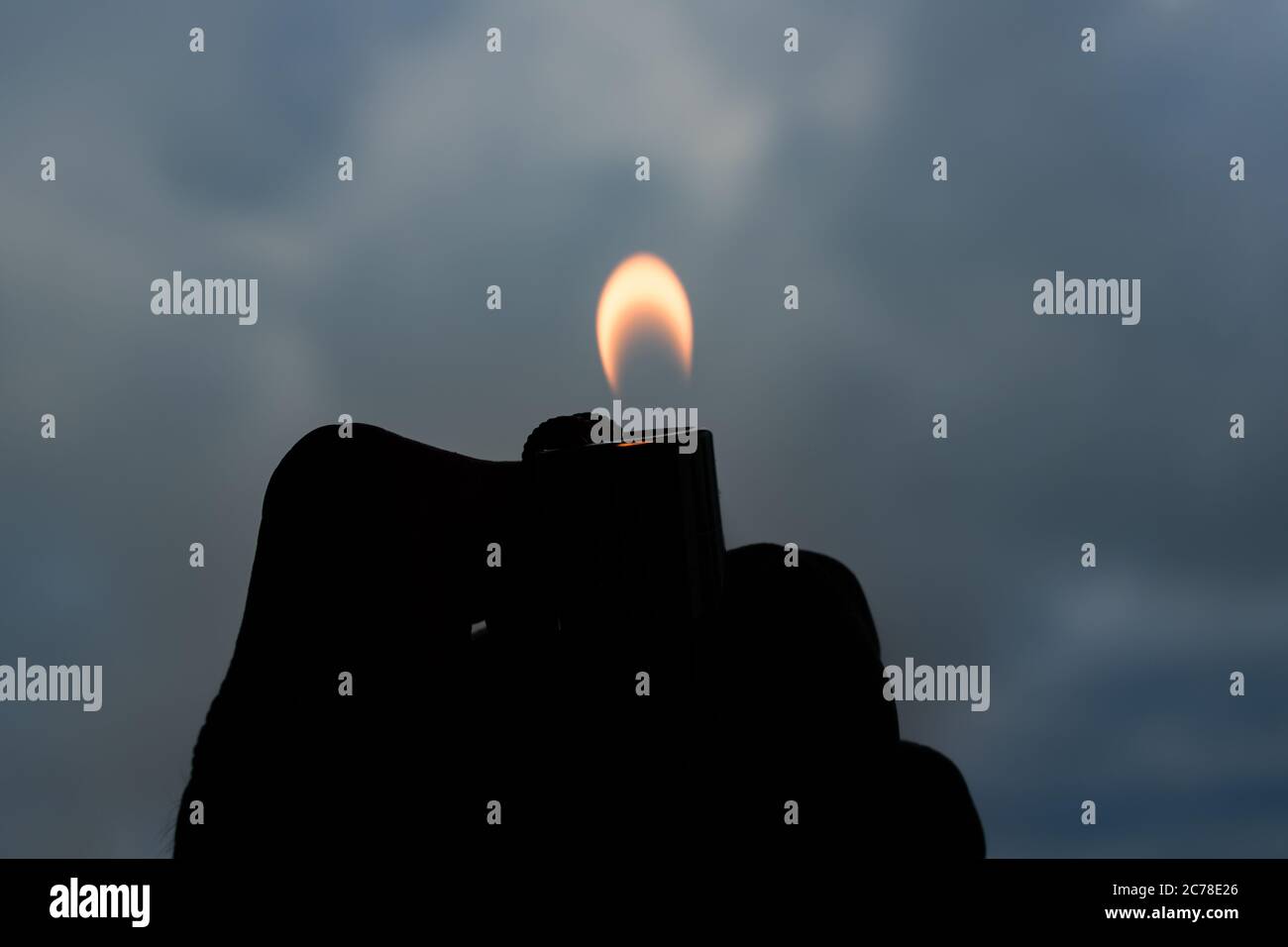 Burning lighter in hand on the night sky Stock Photo - Alamy