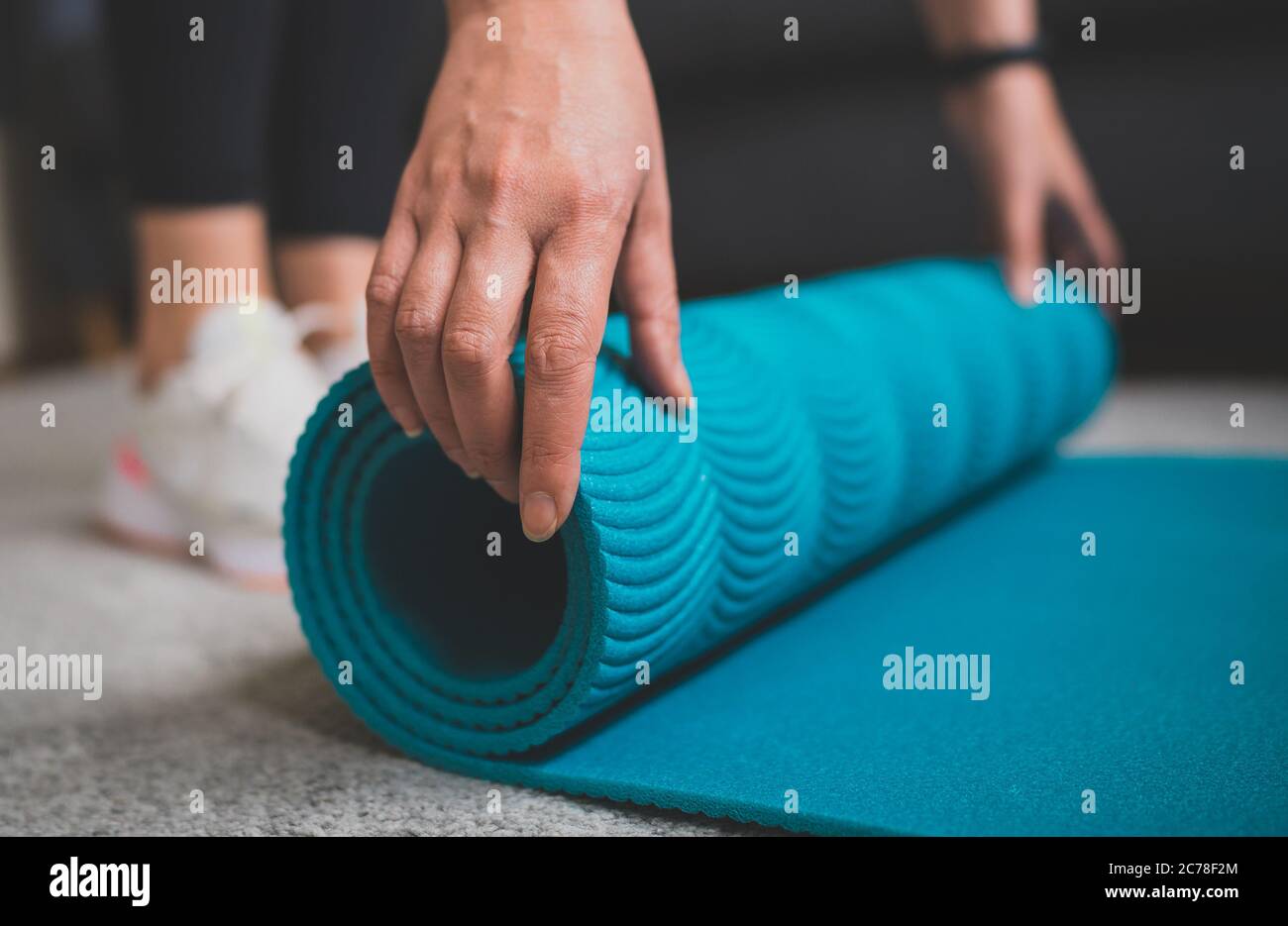 Woman rolling yoga mat. Home fitness training concept Stock Photo - Alamy