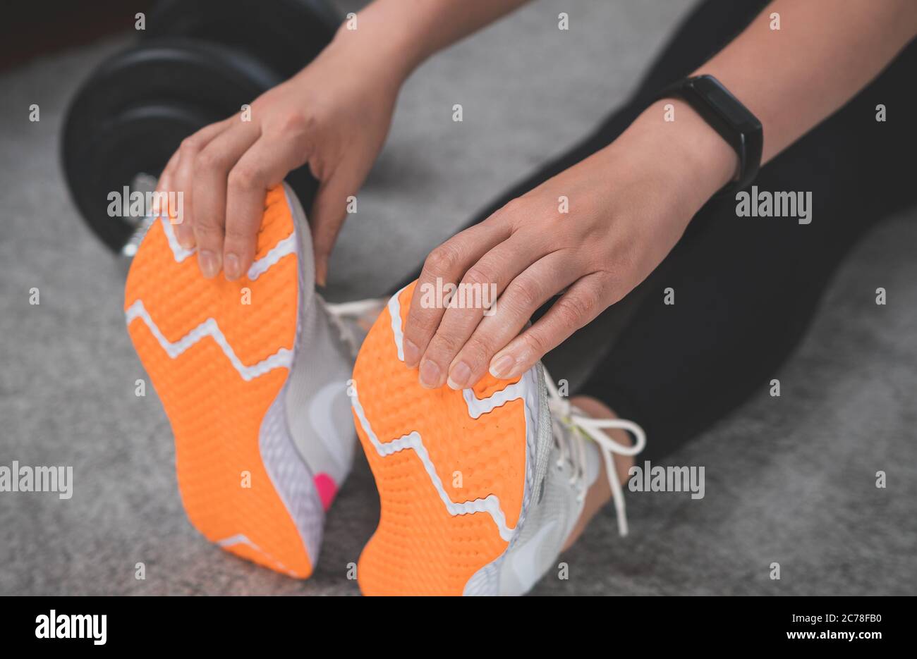 Woman stretches his leg before exercise. Home fitness training concept ...