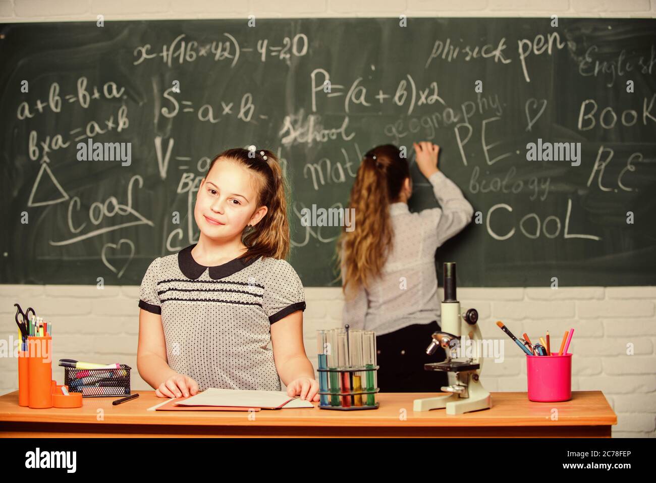 Using modern technologies. Little girls scientist work with microscope ...