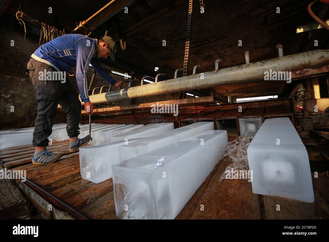 Baghdad, Iraq. 15th July, 2020. A worker pulls ice blocks at the ice ...