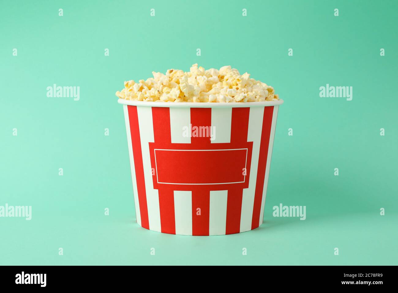 Cardboard bucket with tasty popcorn on mint background Stock Photo - Alamy