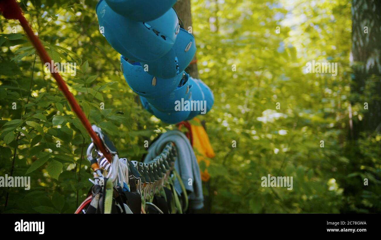 Insurance belts and helmets hanging on the rope in forest. Mid shot ...