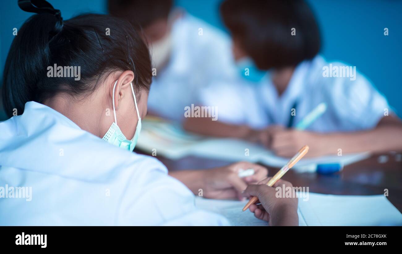 Uniform students wearing hygienic mask while studying in the classroom ...