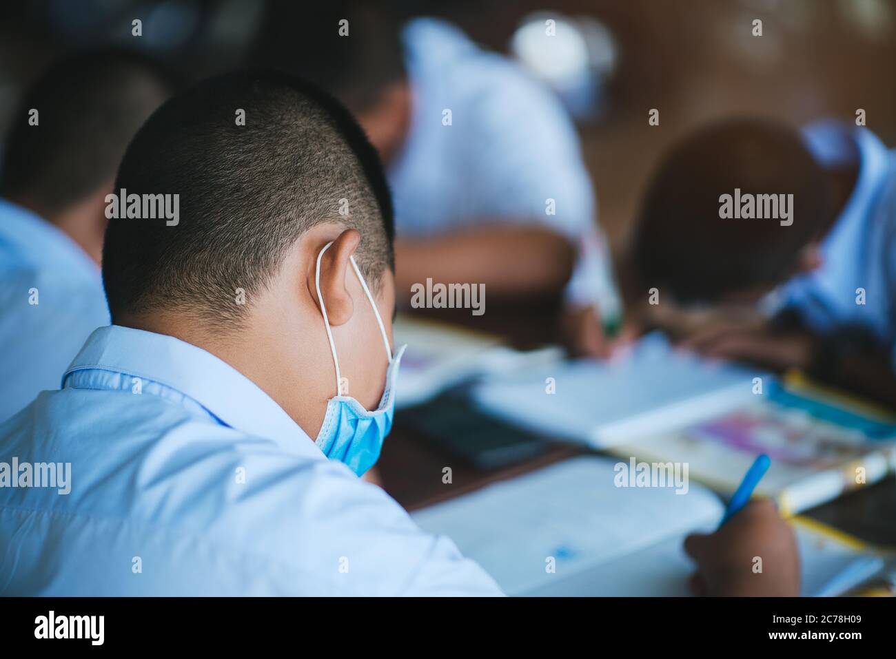Uniform students wearing hygienic mask while studying in the classroom ...