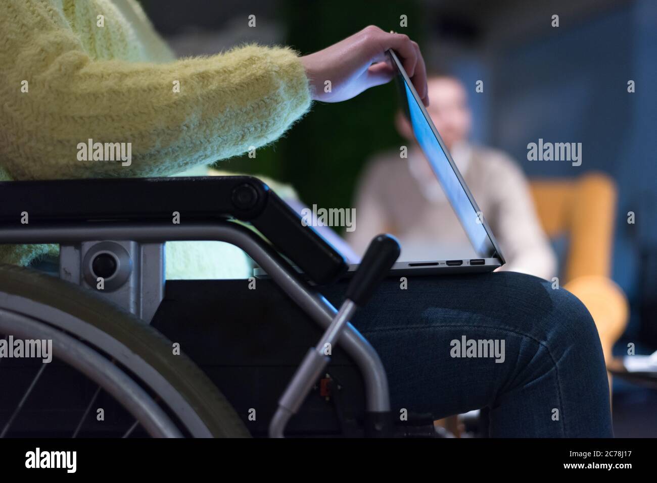 Disabled businesswoman in the wheelchair using her laptop while ...