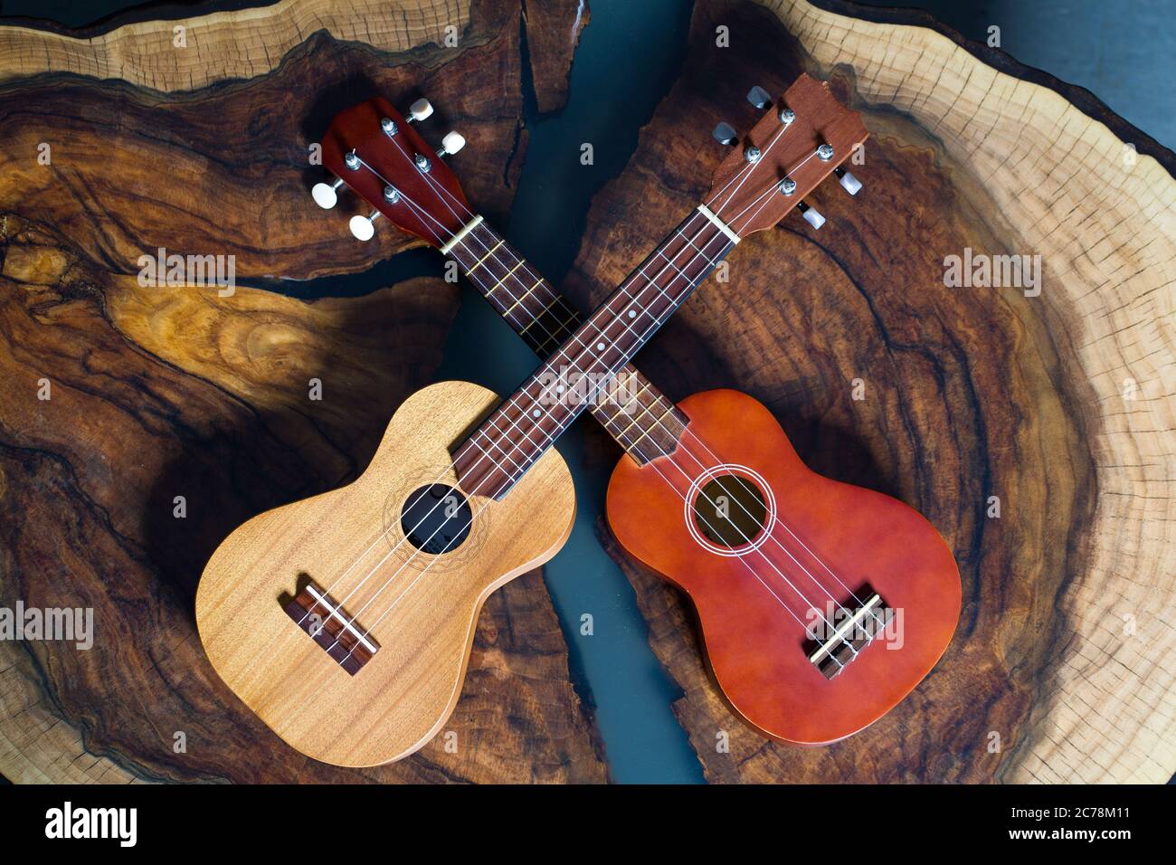 Two ukuleles in different colors - light and dark brown on beautiful ...